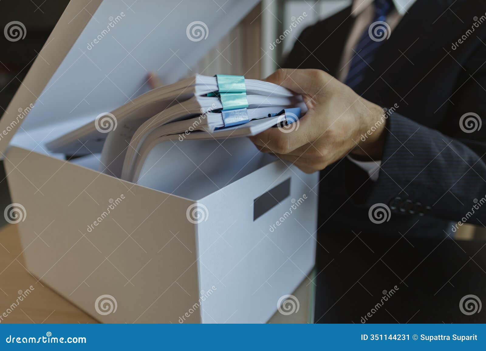 An Office Worker is Putting Important Documents in Boxes To Prevent ...