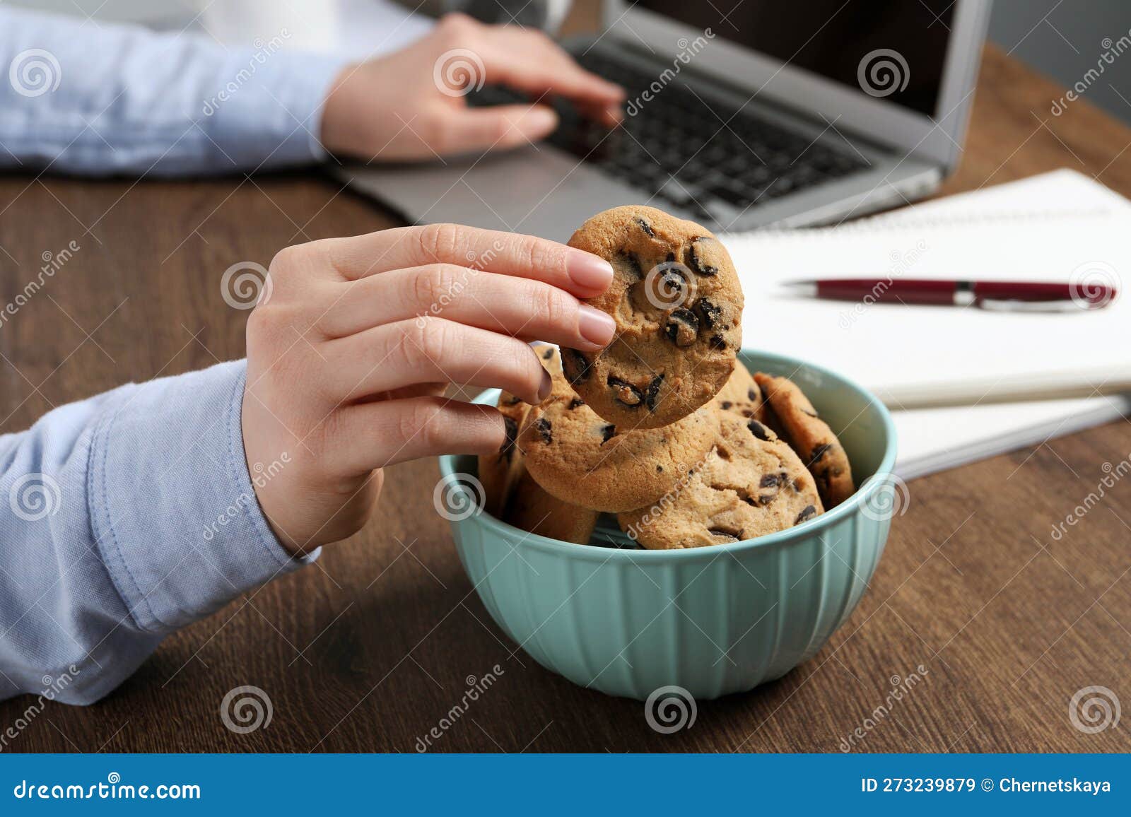 Office Worker Taking Chocolate Chip Cookie from Bowl at Workplace ...