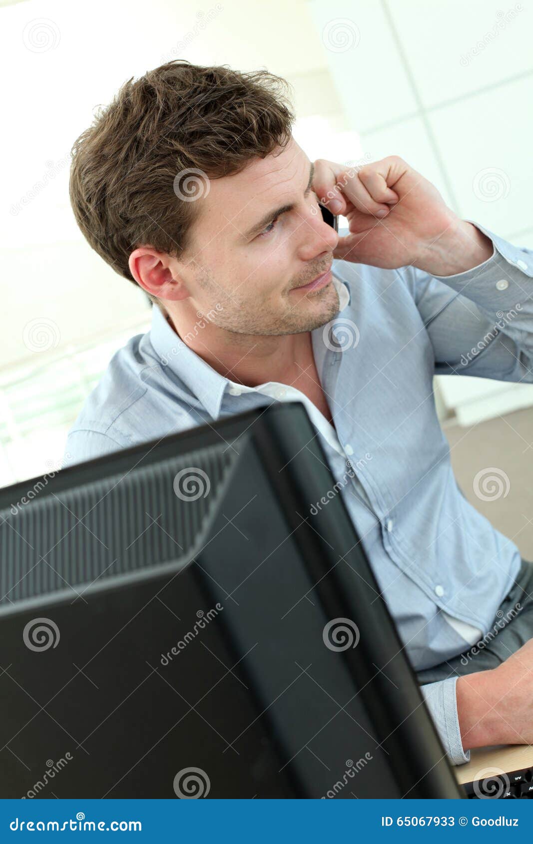 Office Worker Working on Computer and Talking on the Phone Stock Image ...