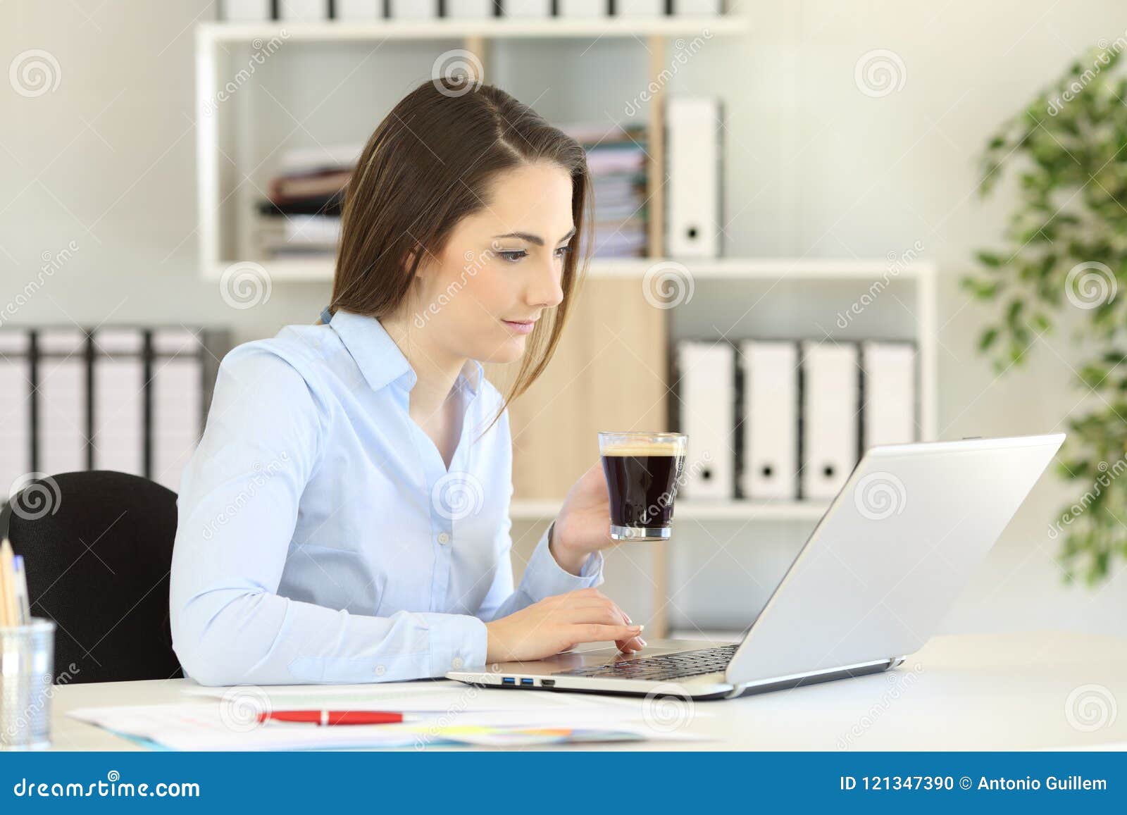 Office Worker Working Online Holding a Coffee Cup Stock Photo - Image ...