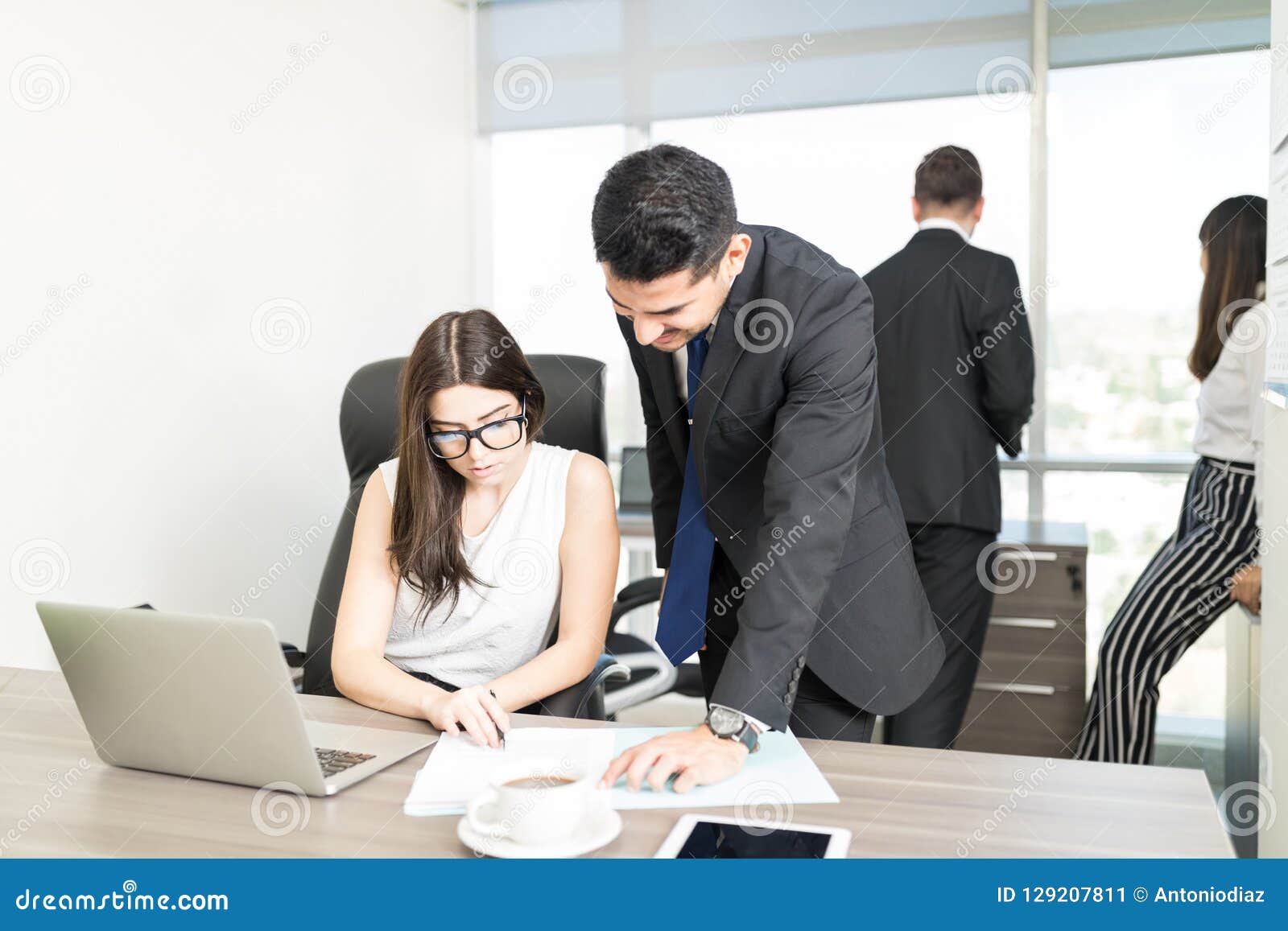 Office Workers Discussing Document at Desk Stock Image - Image of desk ...