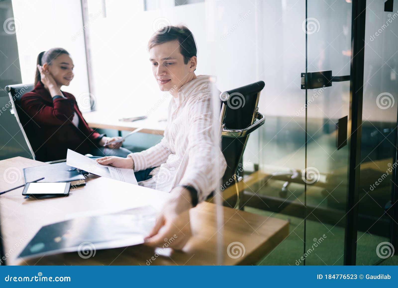 Office Workers Talking Behind Glass Door and Picking Up Documents Stock ...