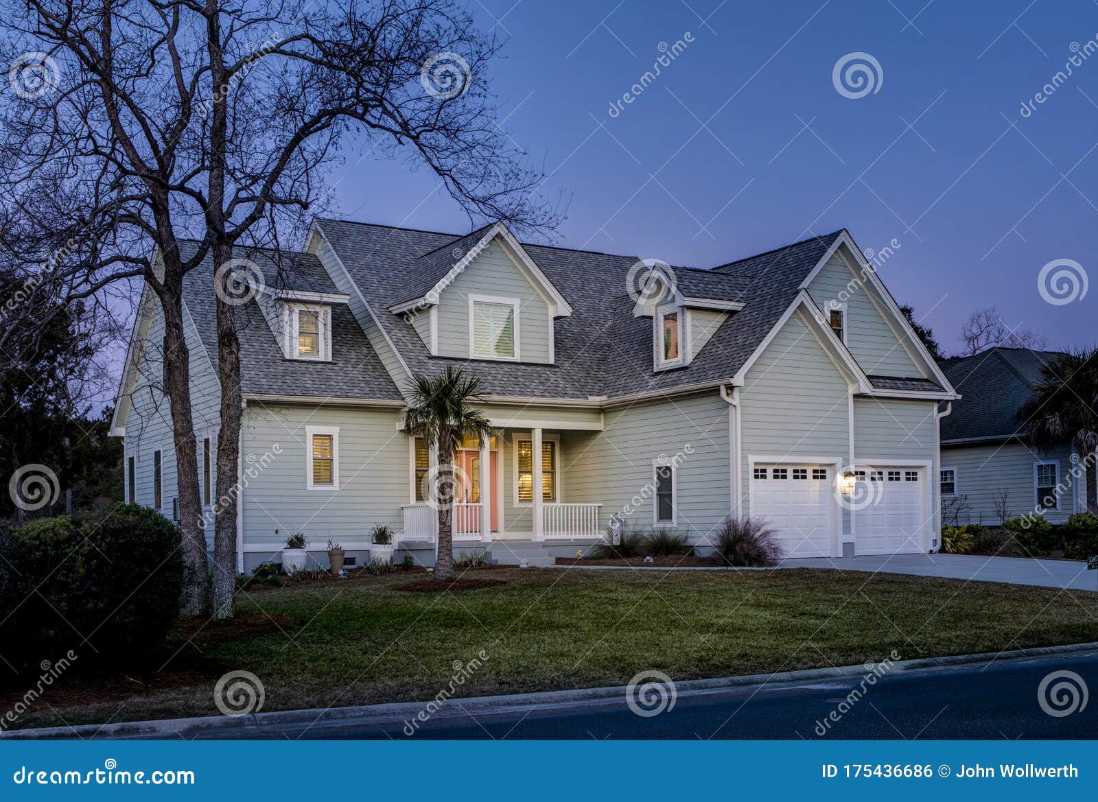 Offset View of Beautiful Luxury Home at Dusk with Lights Stock Photo ...