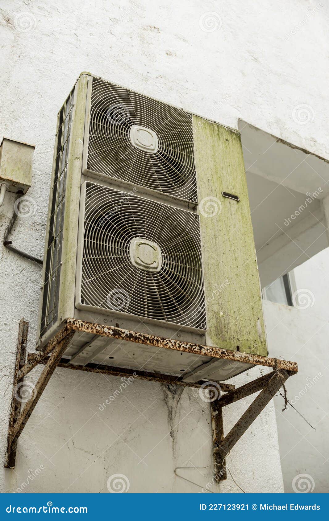 An Old and Aging Split Type Air Conditioner Condenser Mounted on the ...