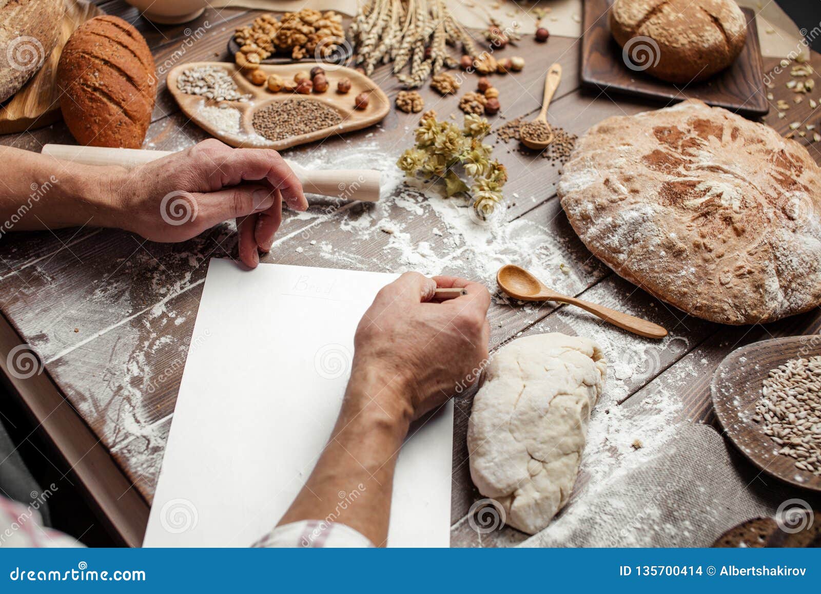 Old Baker Writing Down Old-time Recipe in Bakery Notebook Surrounded by ...