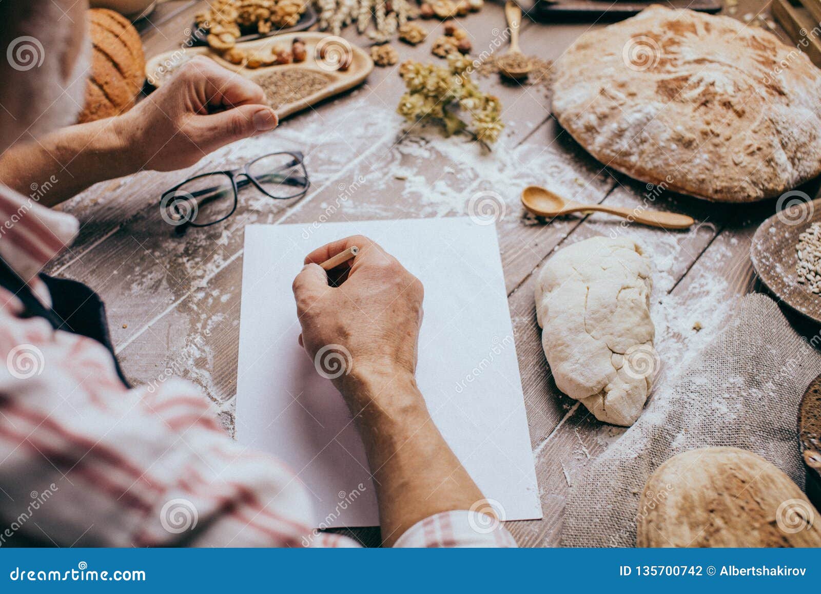 Old Baker Writing Down Old-time Recipe in Bakery Notebook Surrounded by ...