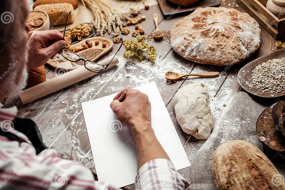 Old Baker Writing Down Old-time Recipe in Bakery Notebook Surrounded by ...