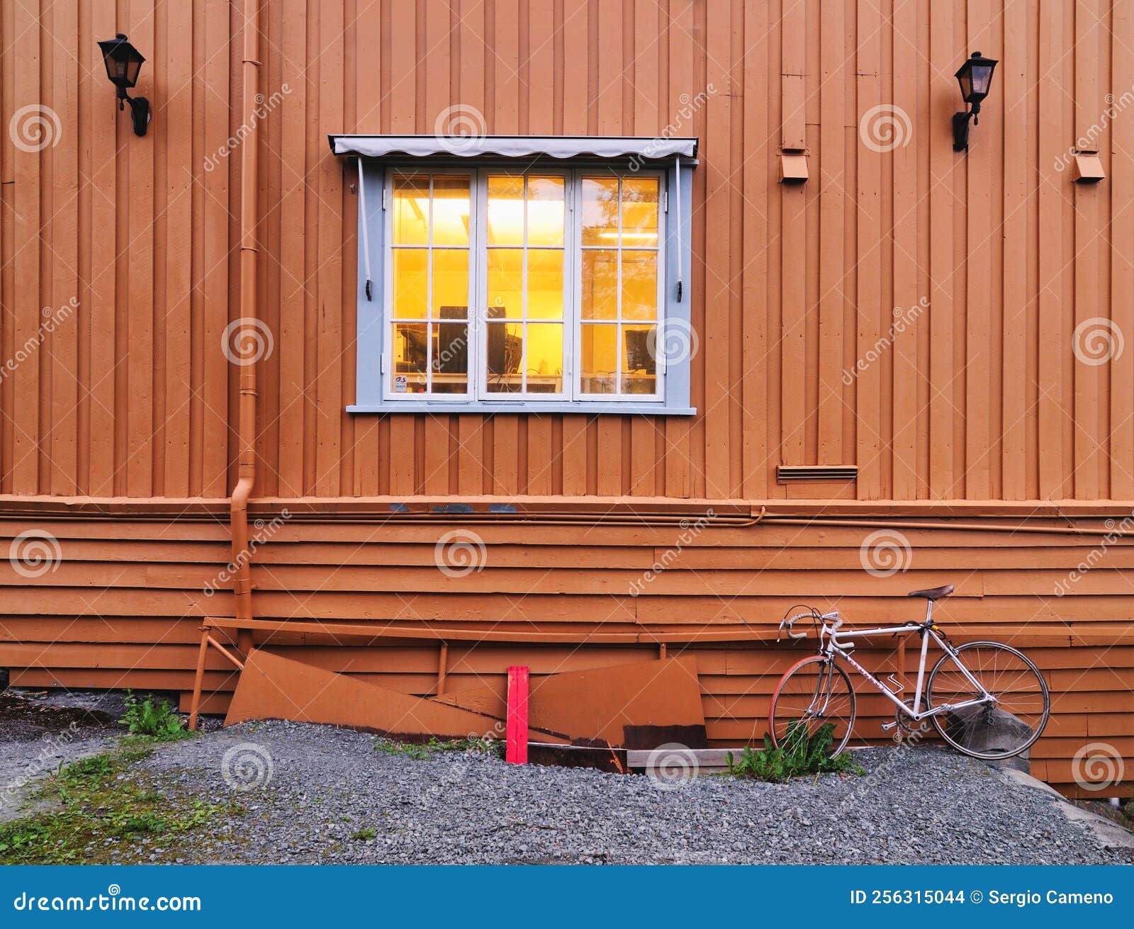 An Old Bicycle Under the Window of a House with Lights on Stock Photo ...