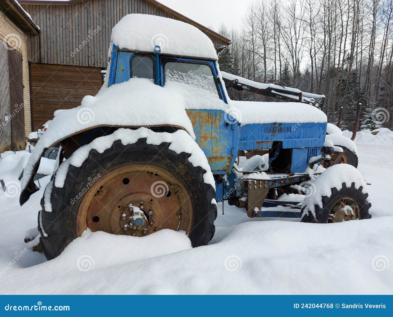 Old Blue Tractor Standing Covered in Snow Stock Photo - Image of tire ...