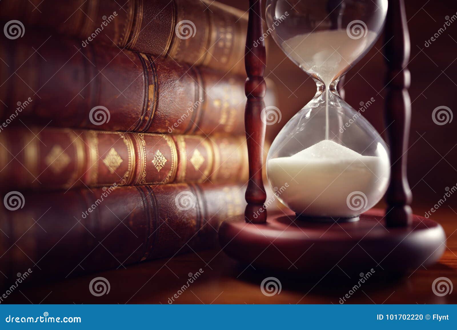 Hourglass And Book On A Table, With A Blackboard Background Royalty ...
