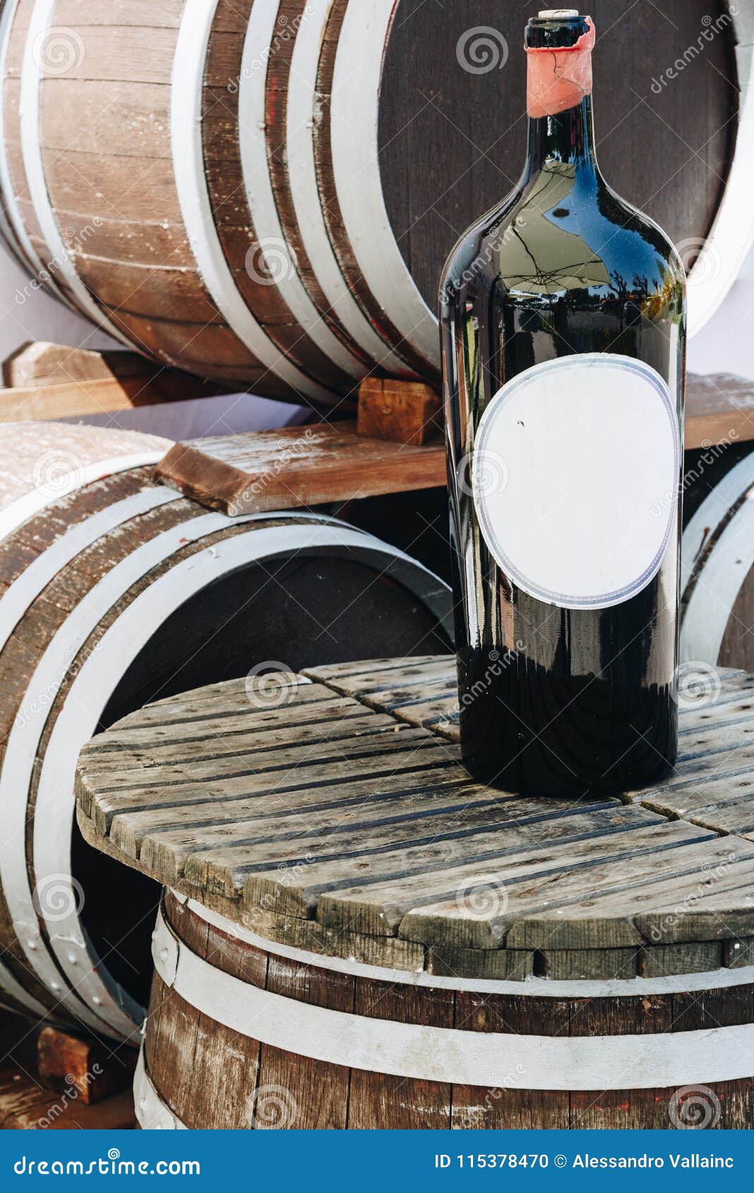 Old Bottle of Wine with Blank Label on Wine Barrel. Stock Photo - Image ...