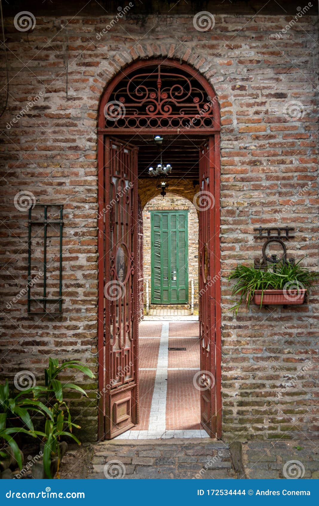 Old Brick Arch with Rusty Iron Gate Open, Leading To a Passage with a ...
