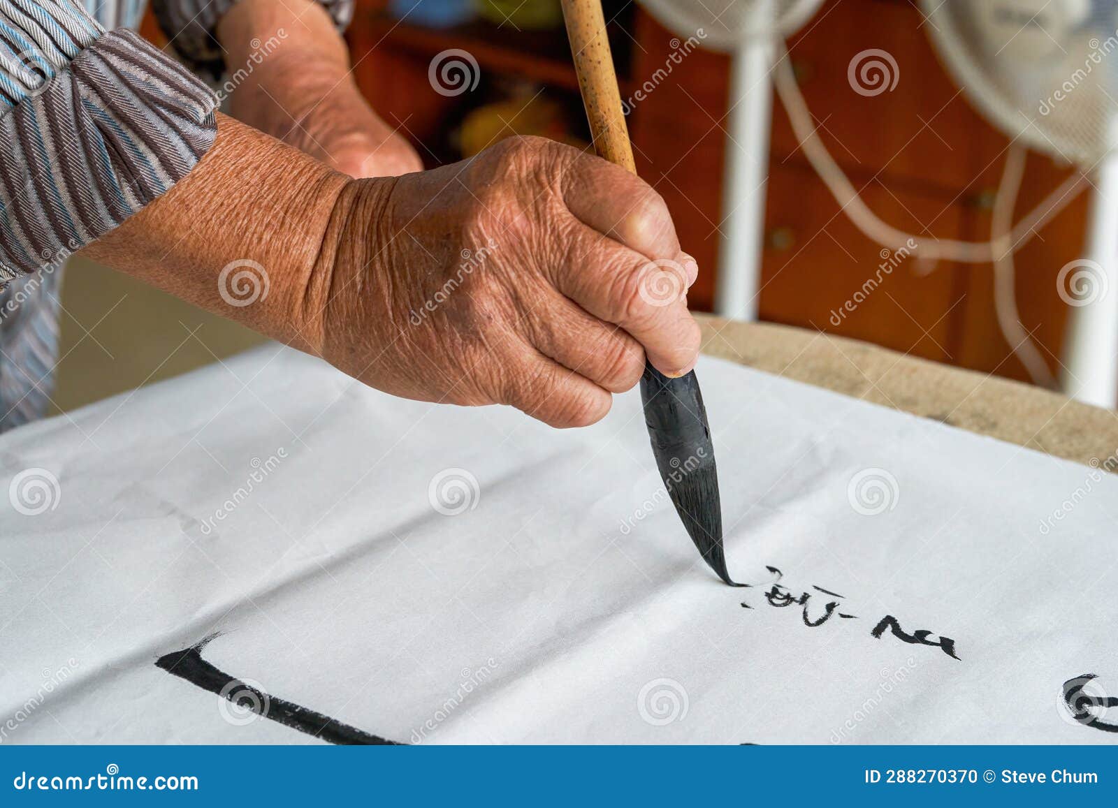 An Old Chinese Calligrapher is Writing Calligraphy Characters, Creating ...