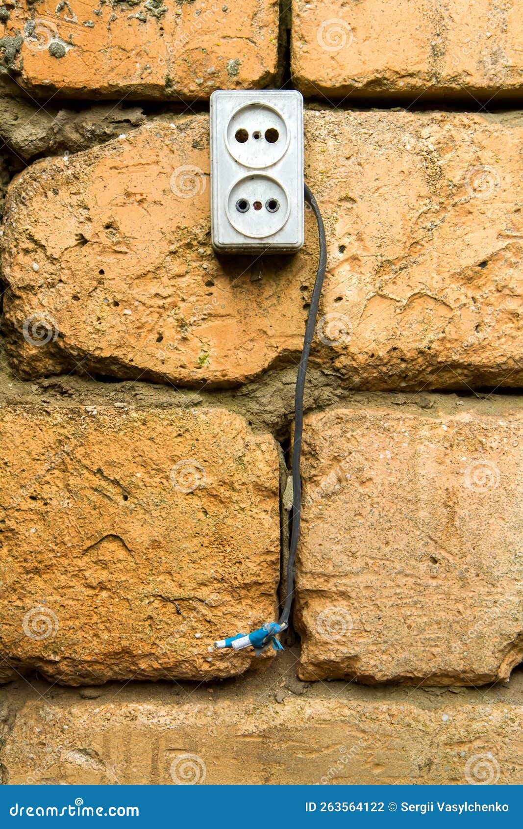 An Old Electrical Outlet with Dangling Wire on a Brick Wall. Stock ...