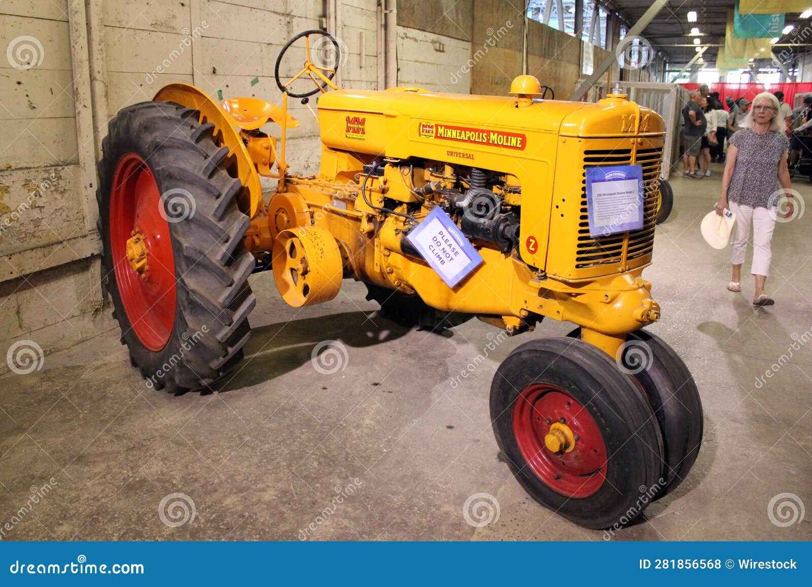 Old-fashioned Tractor Located in a Warehouse, with a Woman Walking by ...