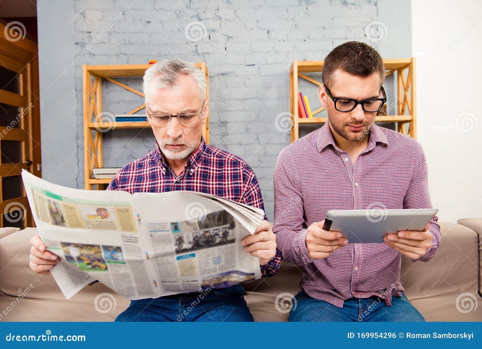 Old Father Reading Newspaper and His Son Using Tablet Stock Photo ...