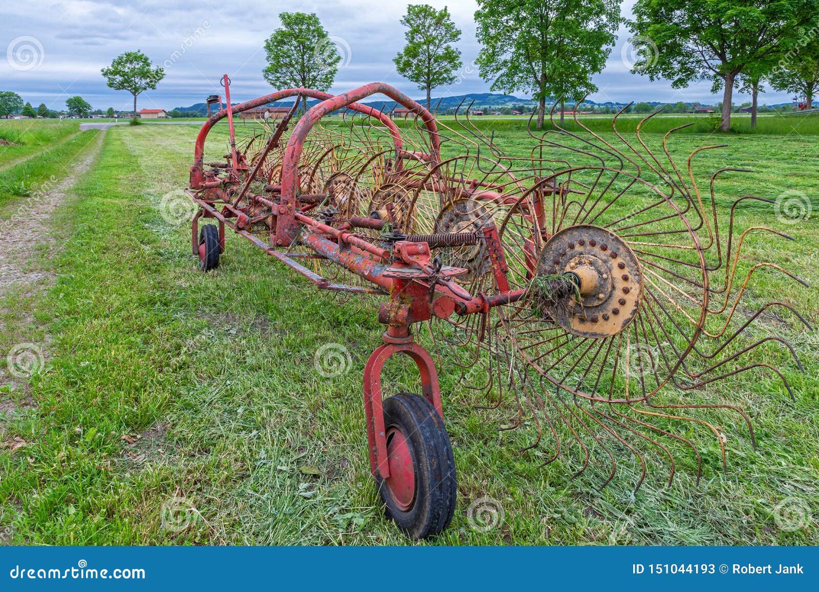 Old hay tedder on a meadow stock image. Image of green - 151044193