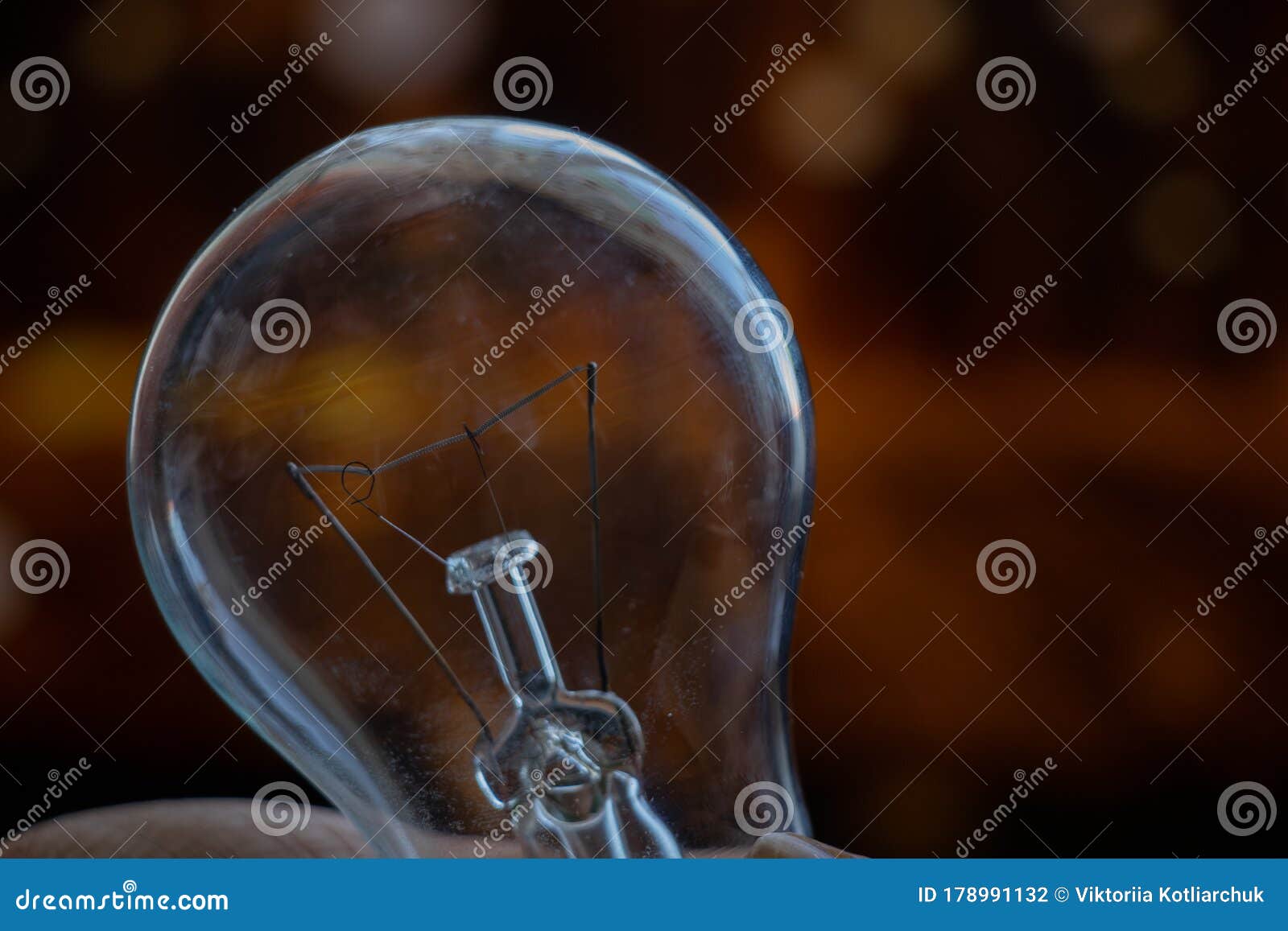 Old Incandescent Light Bulb in Hand on Blurry Dark Background Close-up ...