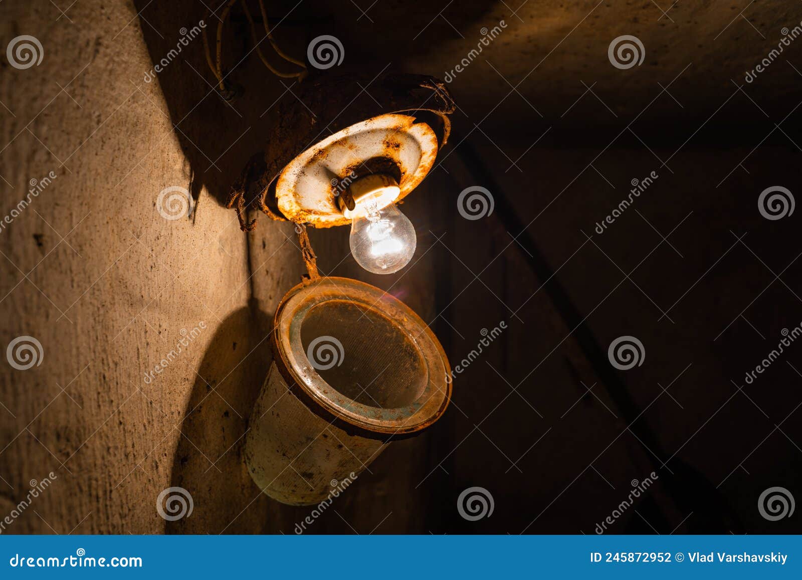 An Old Incandescent Light Bulb in an Old Rusty Ceiling Lamp in a Dark ...