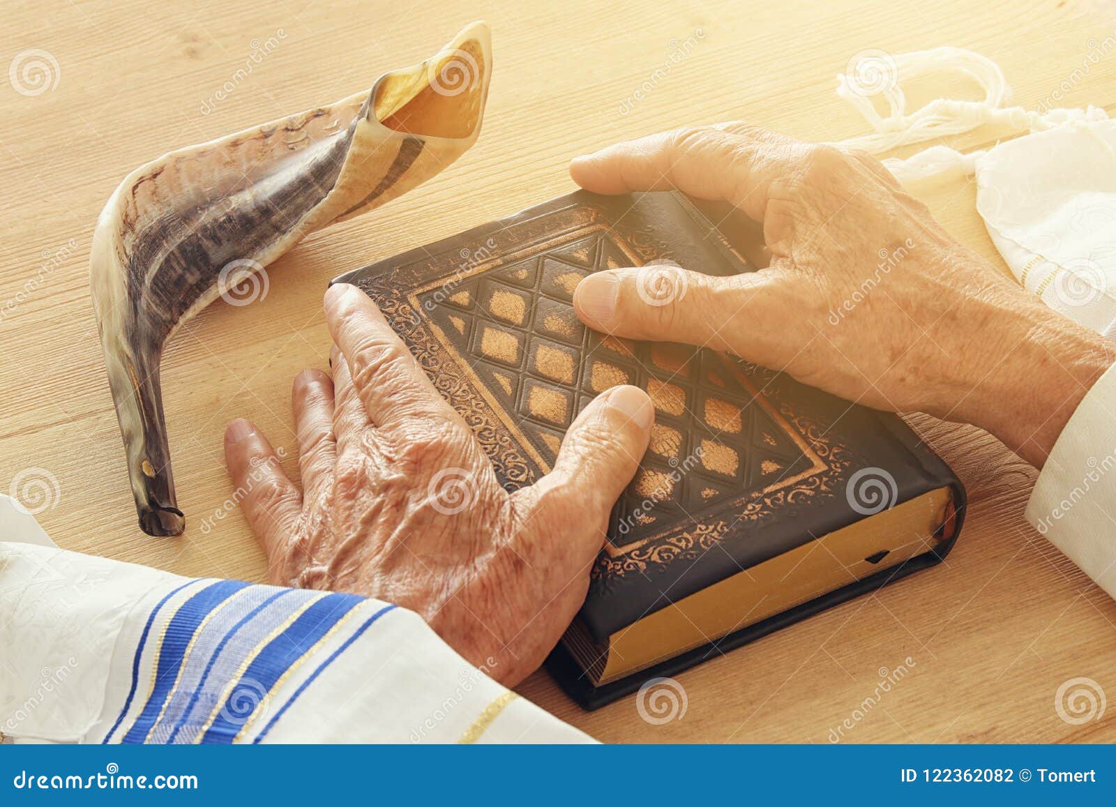 Old Jewish Man Hands Holding a Prayer Book, Praying, Next To Tallit and ... Old Jewish Man Hands Holding a Prayer Book, Praying, Next To Tallit and ...