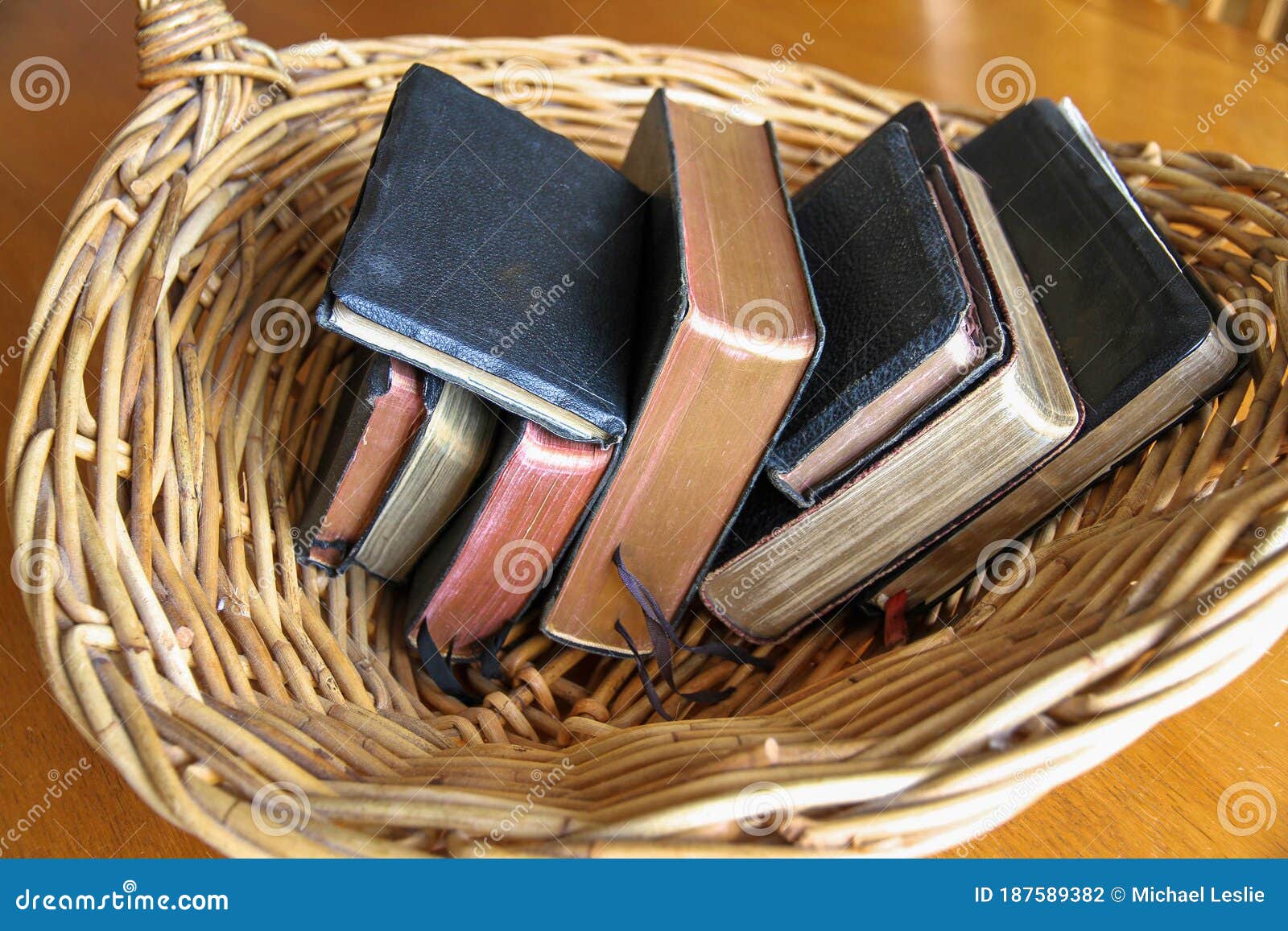 A Stack of Old Leather Bound Books and Bibles Sitting in a Woven Basket ...