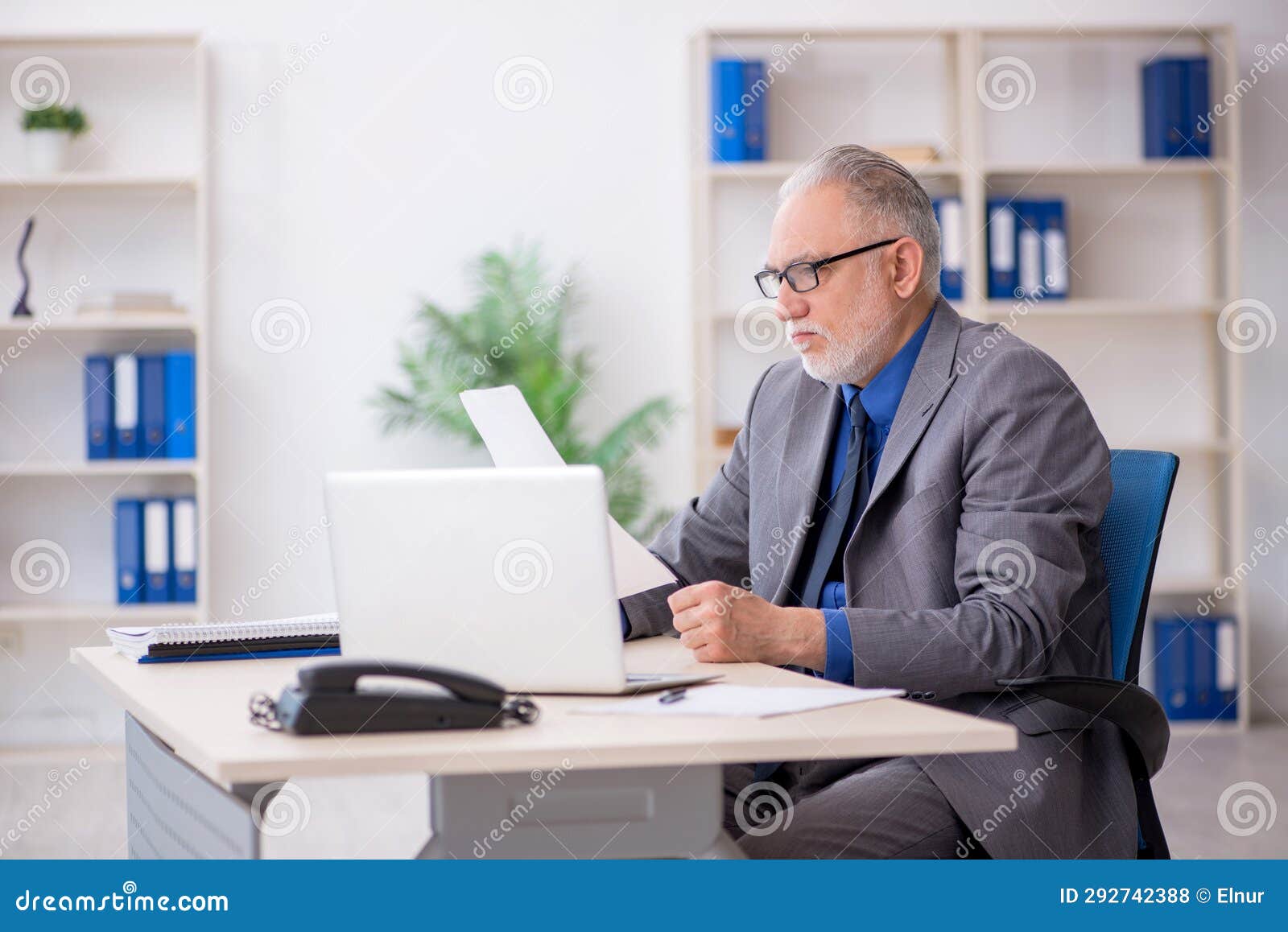 Old Male Employee Reading Paper at Workplace Stock Photo - Image of ...