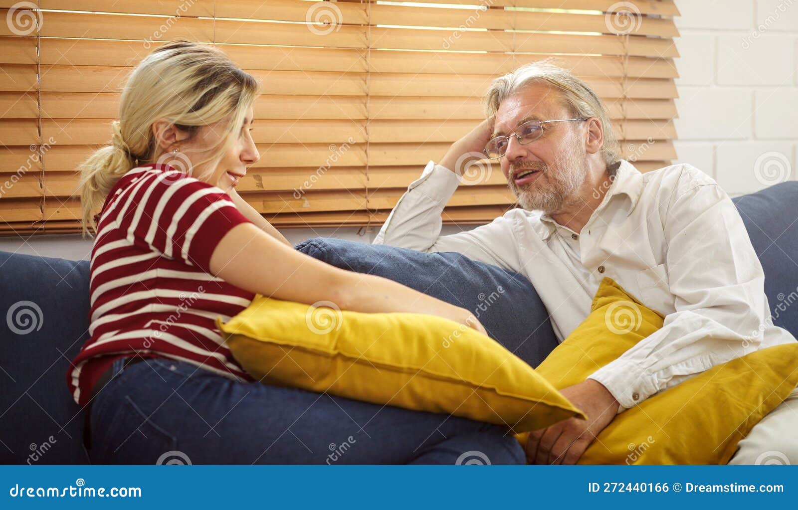 An Old Man and Daughter Talking and Smiling while Sitting on the Sofa ...