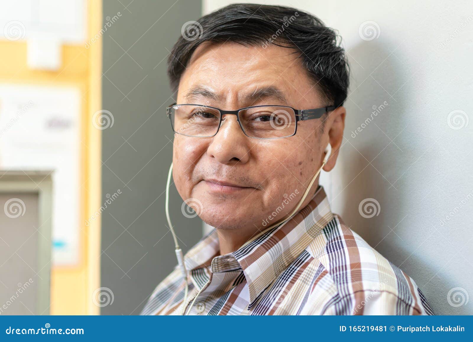 An Old Man Is Happy To Listen To Music Using Headphones Stock Image
