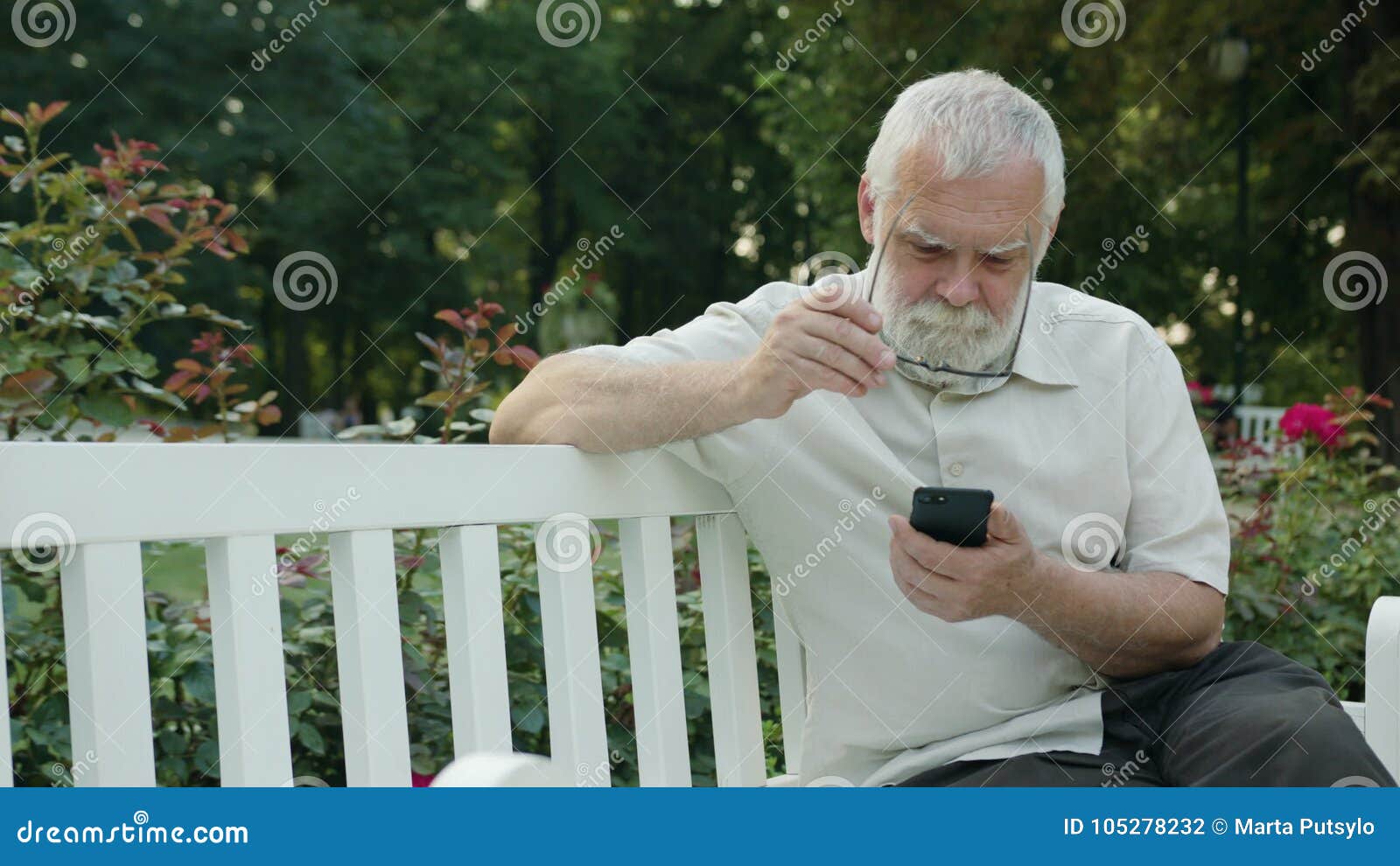 Old Man Using a Phone Outdoors Stock Photo - Image of outdoors, green ...