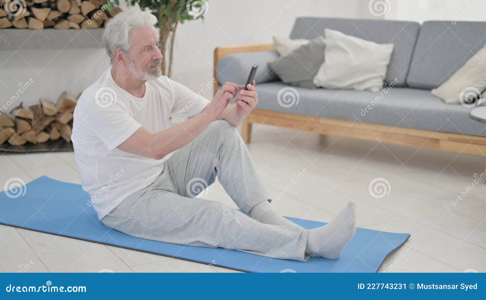 Old Man Using Smartphone on Excercise Mat at Home Stock Image - Image ...