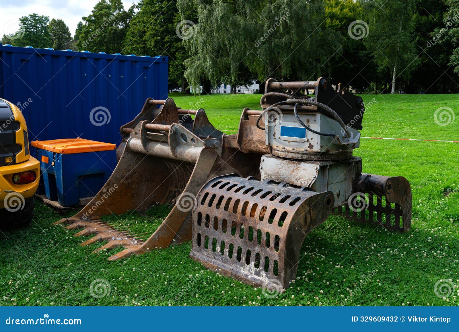 Old Mechanical Grapple Loader on a Green Lawn Next To Construction ...