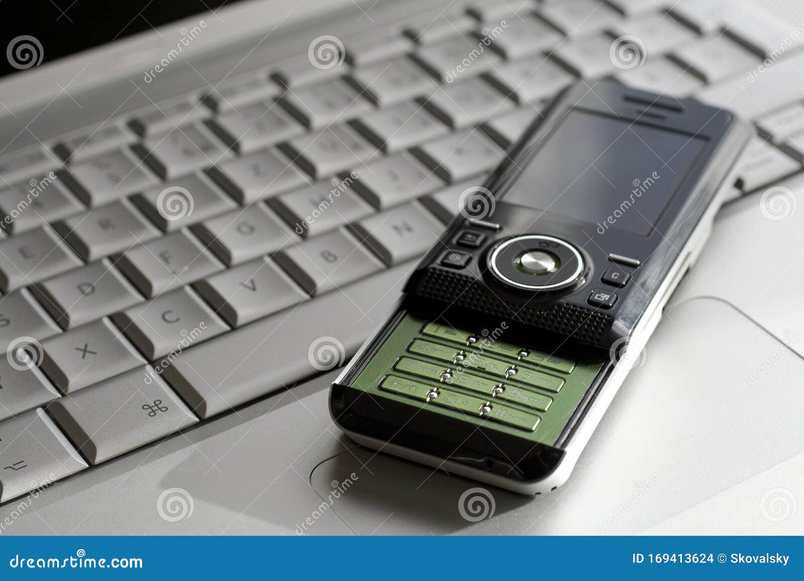 Old Mobile Phone on a Silver Laptop Stock Photo - Image of blank ...