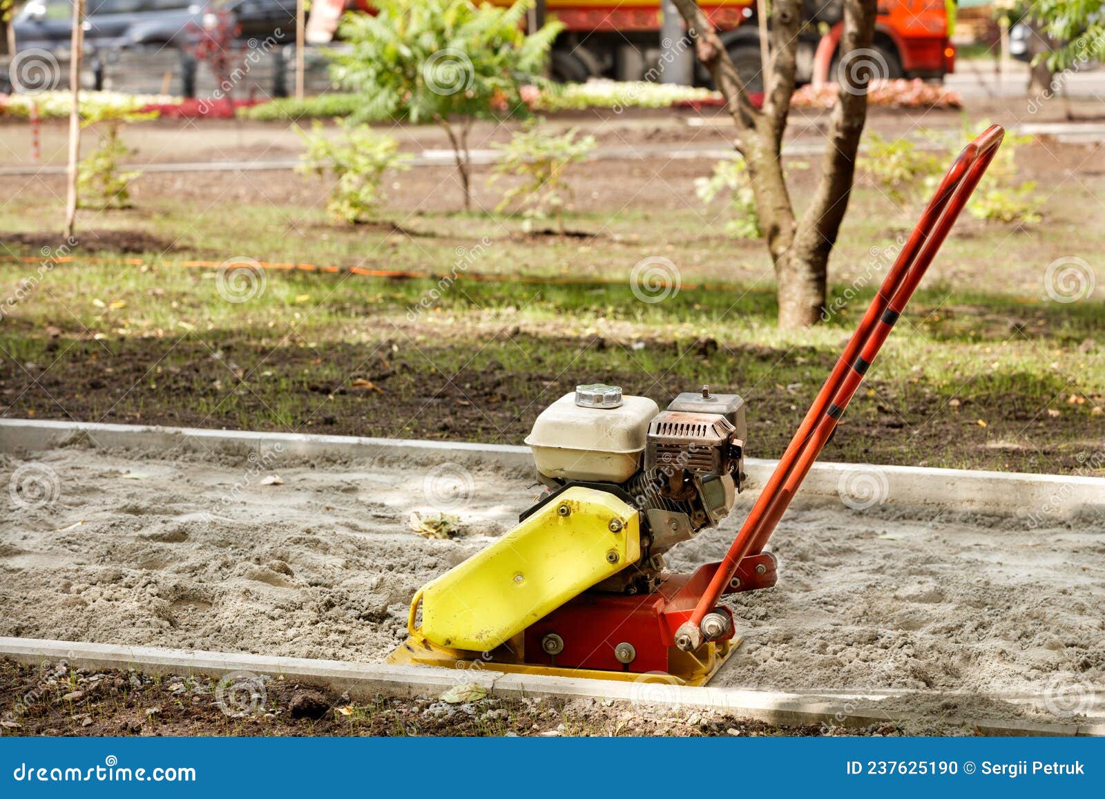 An Old Gasoline Compactor For Compacting Sandy Soil Stands Opposite A ...