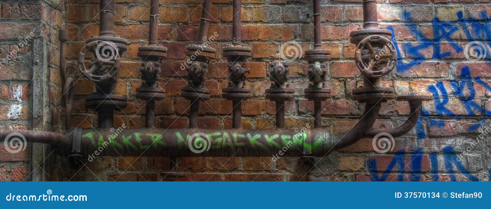 Old Pipes with Valves on a Wall with Graffiti Stock Photo - Image of ...