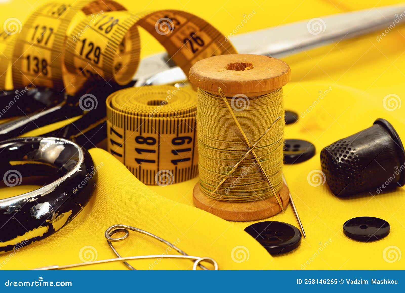 Old Retro Sewing Accessories Lie on a Yellow Fabric. Needle and Thread ...