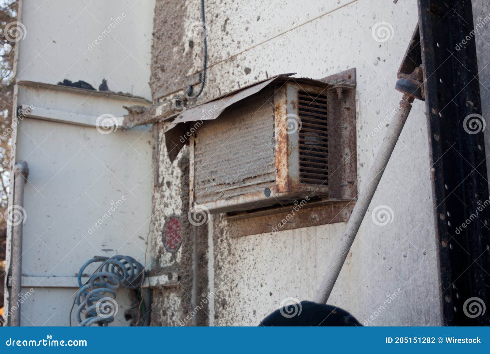 Old Rusty Air Conditioner Outdoor Unit. Hanging On A White Wall ...