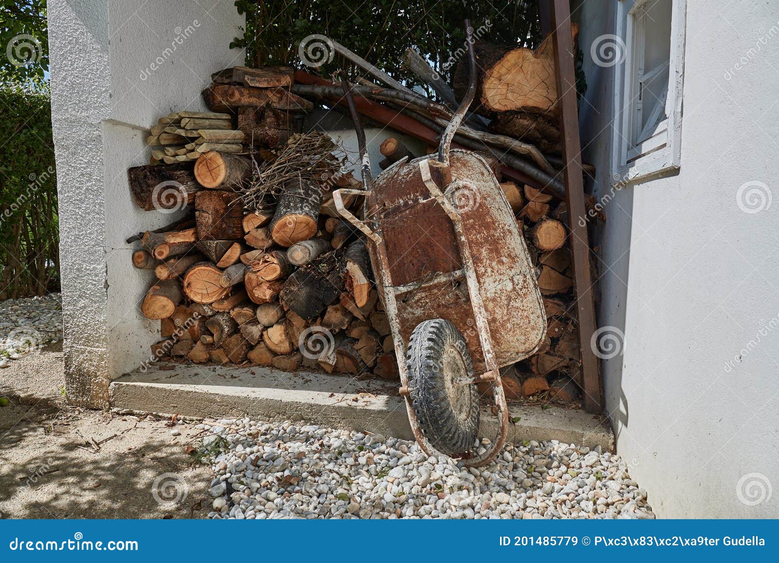 Wheel Barrow in the Garden by the Pile of Logs Stock Image - Image of ...