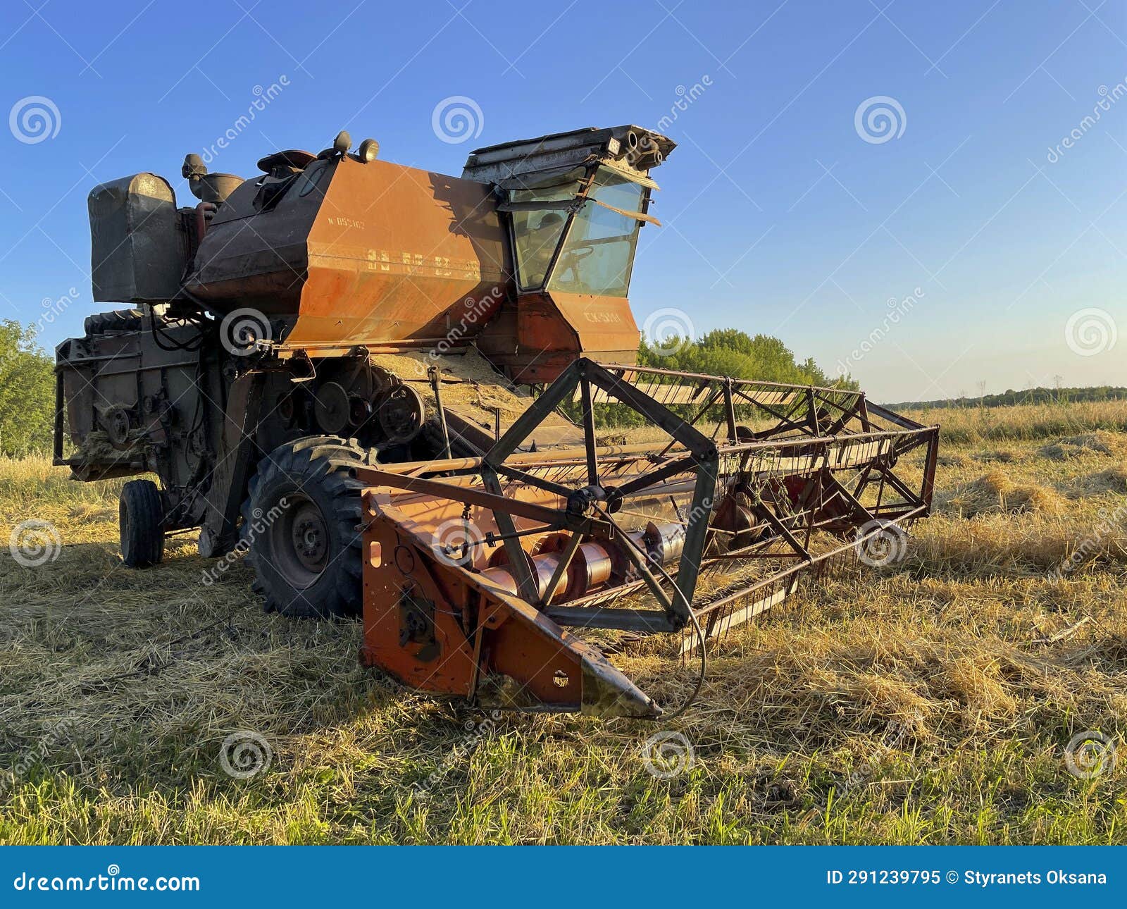 An Old Rusty Combine Harvests Crops in a Field Stock Image - Image of ...