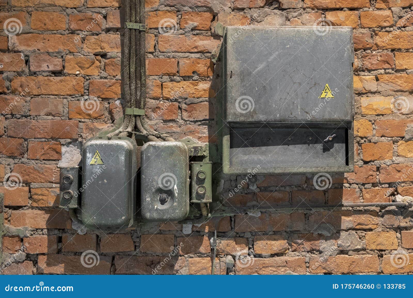 Old Rusty Electrical Panel with Buttons and Wires on a Ragged Red Brick ...