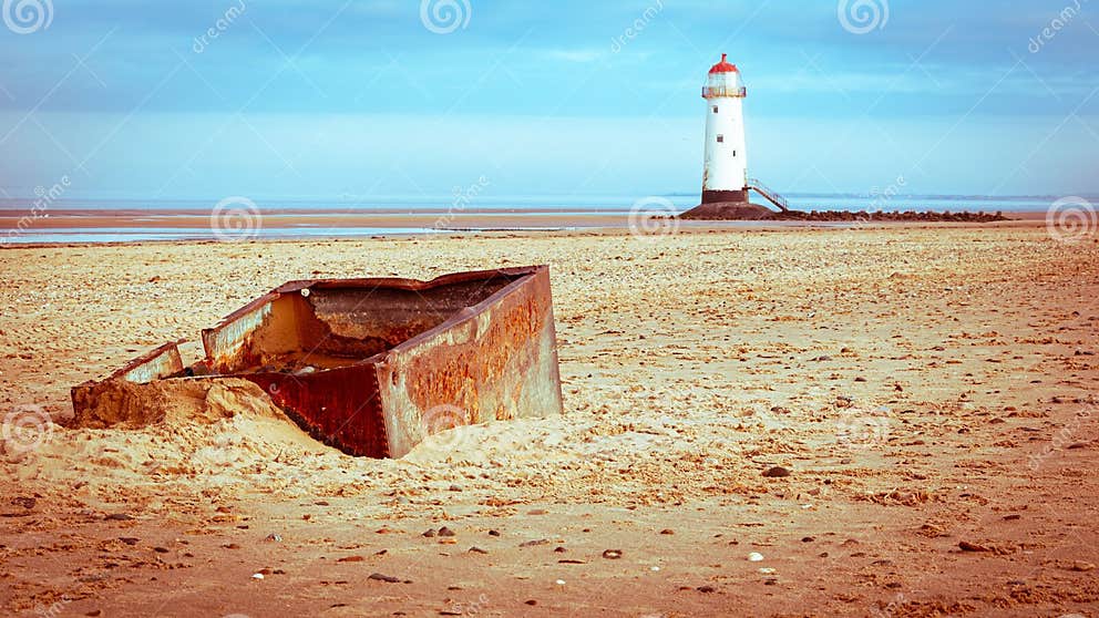 Old Rusty Piece of Metal on an Empty Sandy Beach with a Lighthouse ...