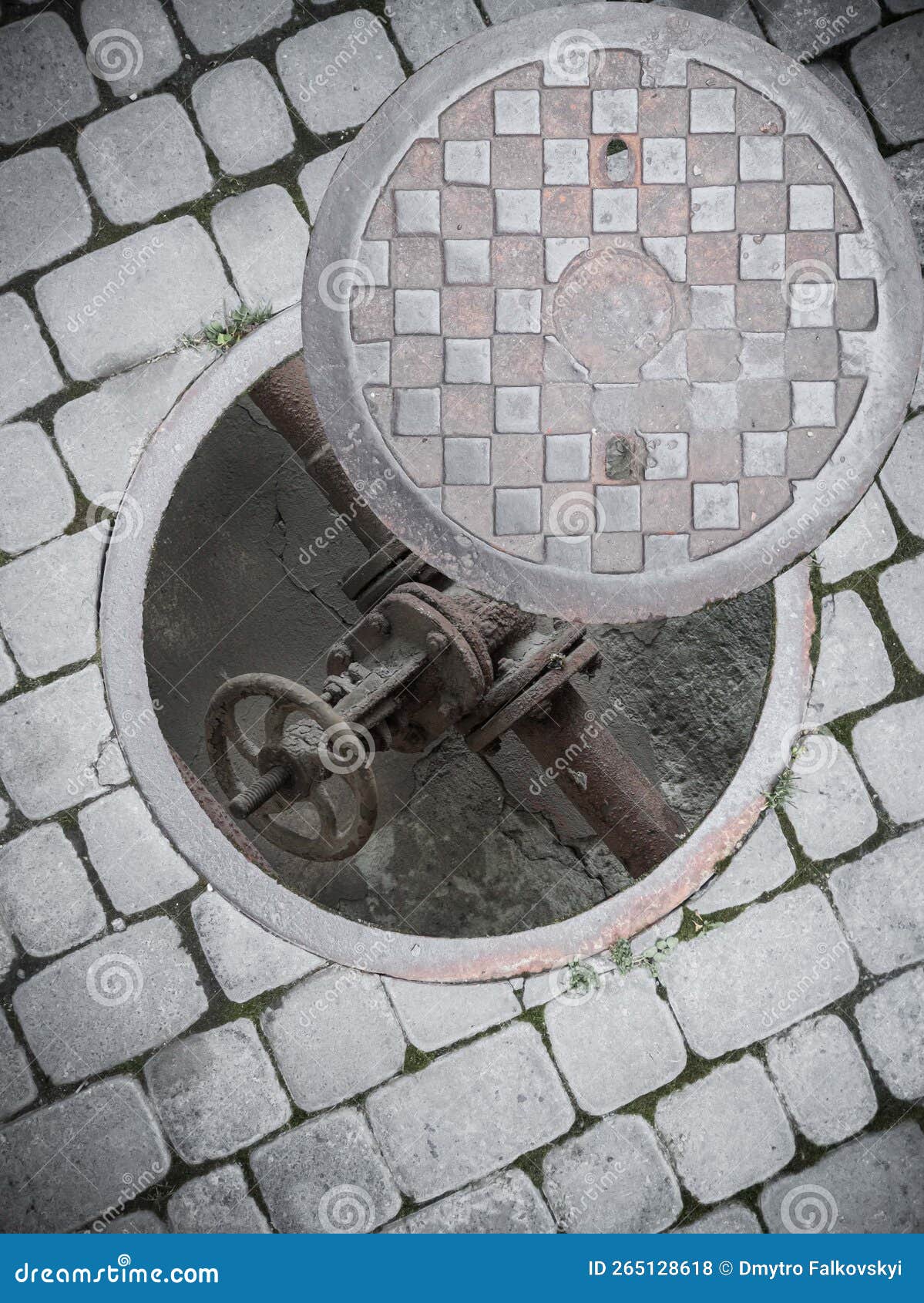 An Old Rusty Pipe at the Bottom of an Open Sewer Manhole on the ...