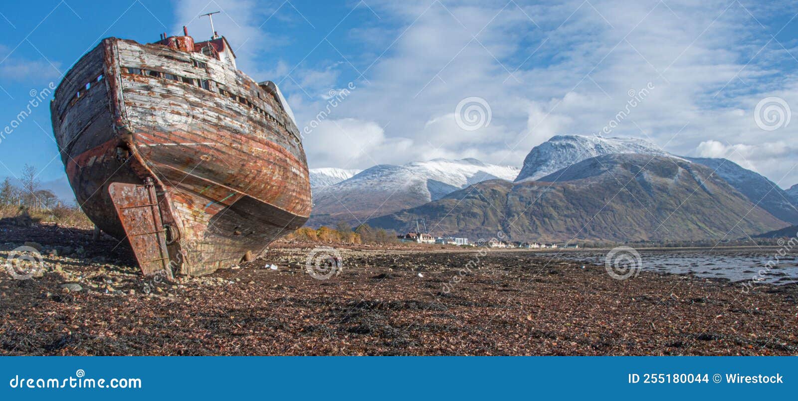 Old Rusty Ship on a Dry Shore with Cloudy Mountains in the Background ...