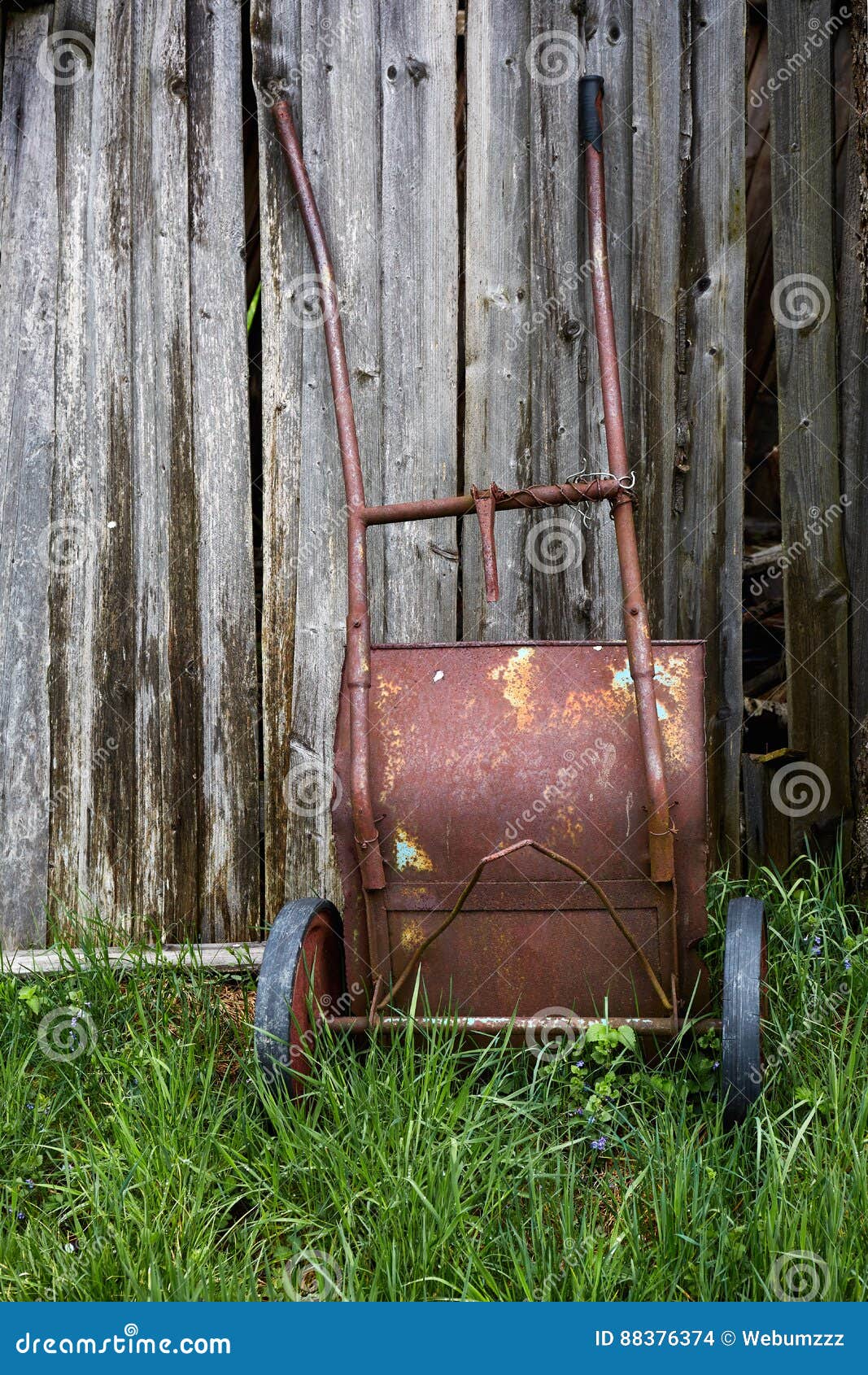 An Old and Rusty Wheelbarrow on Wooden Background Stock Photo - Image ...