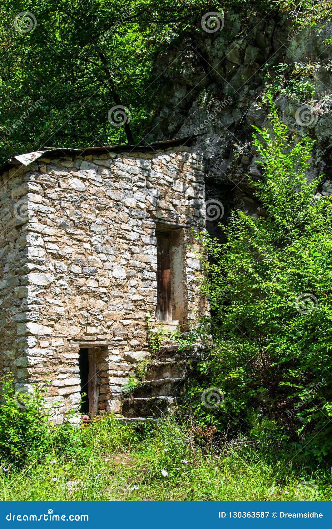 An Old Stone Building Standing by a Rock in the Middle of a Fore Stock ...