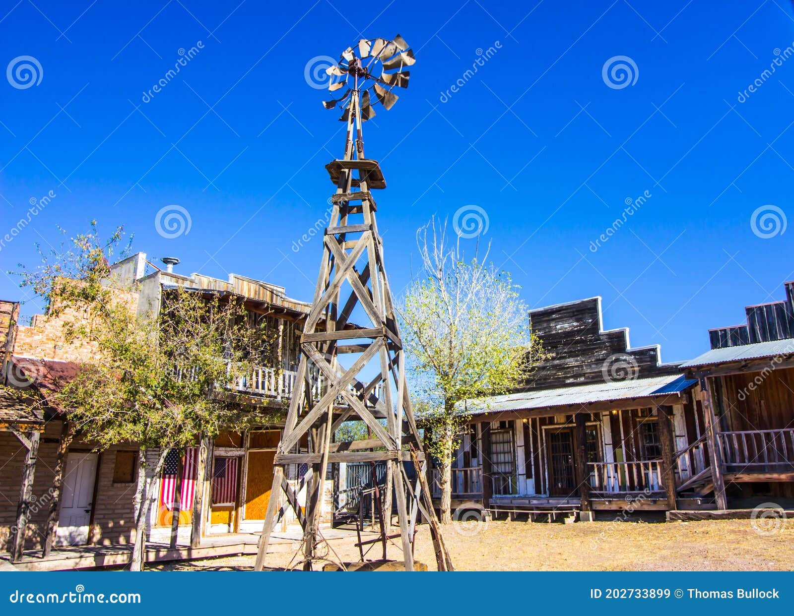 Old Western Windmill & Buildings with Hanging American Flags Stock ...