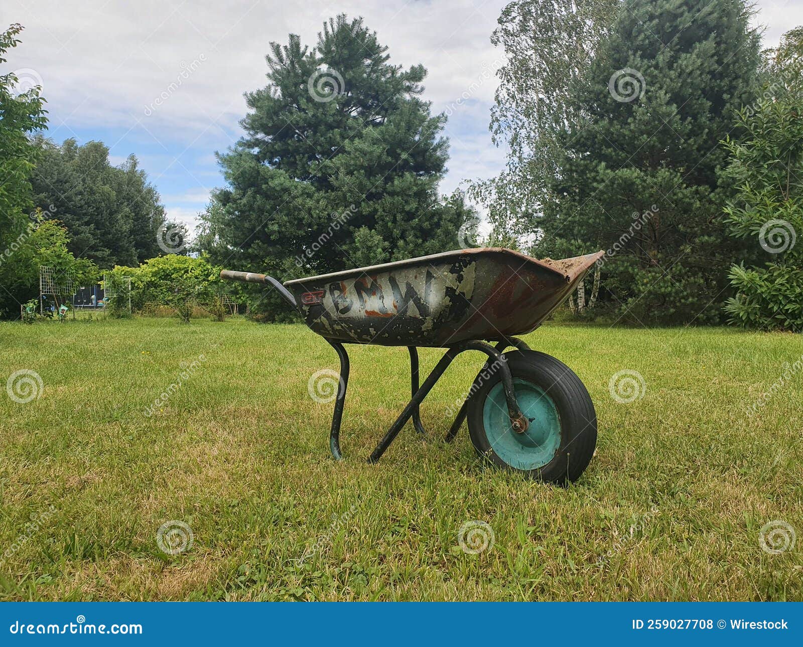 Old Wheelbarrow in the Green Yard. Stock Photo - Image of tool, cart ...