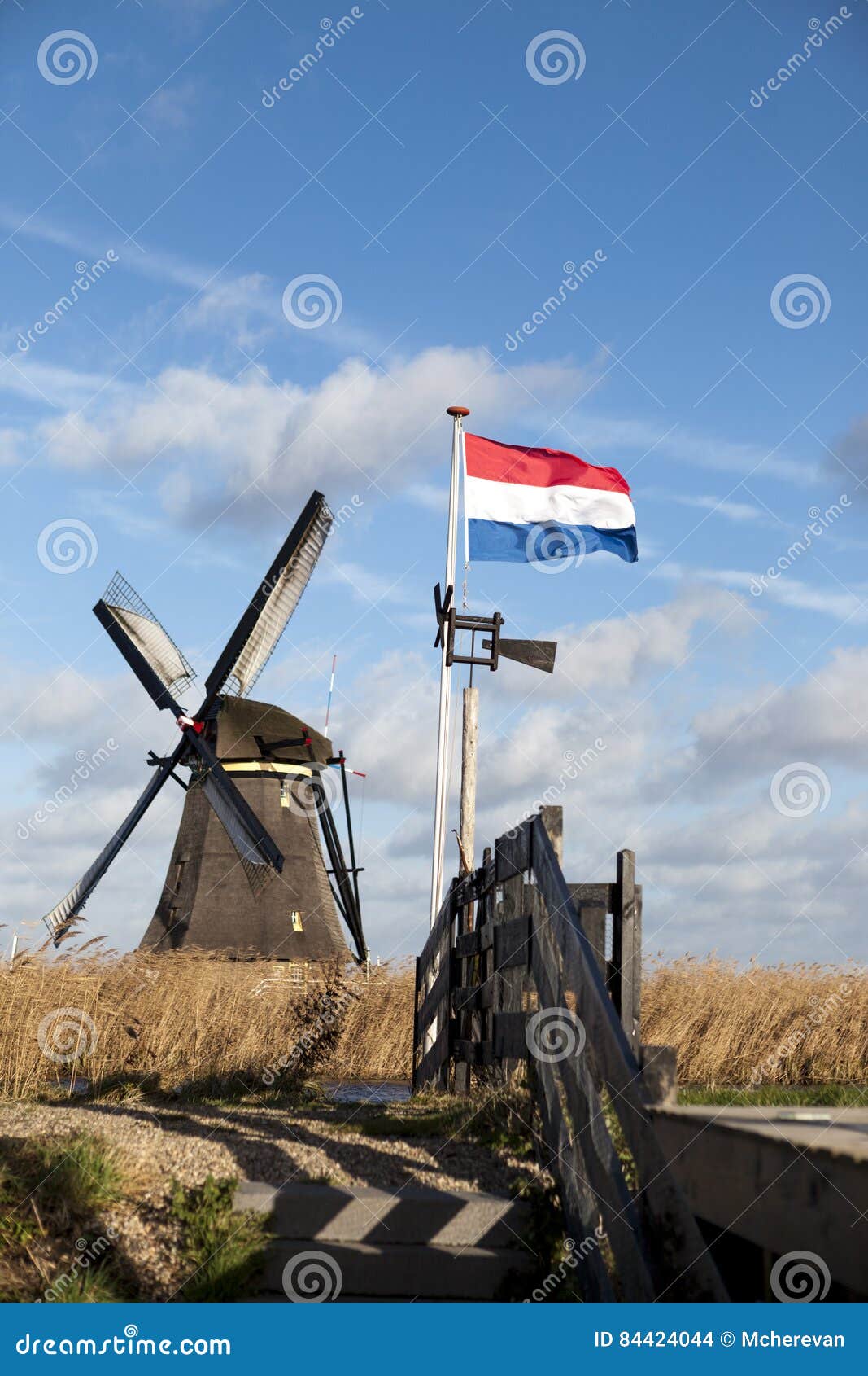 Old Windmill with the Netherlands Flag. White Clouds on a Blue Sky, the ...