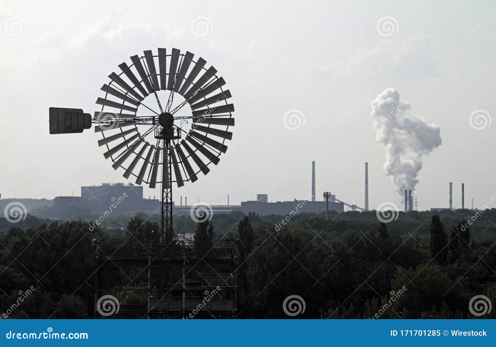 Old Windmill Surrounded by Trees with a Factory in the Distance Stock ...