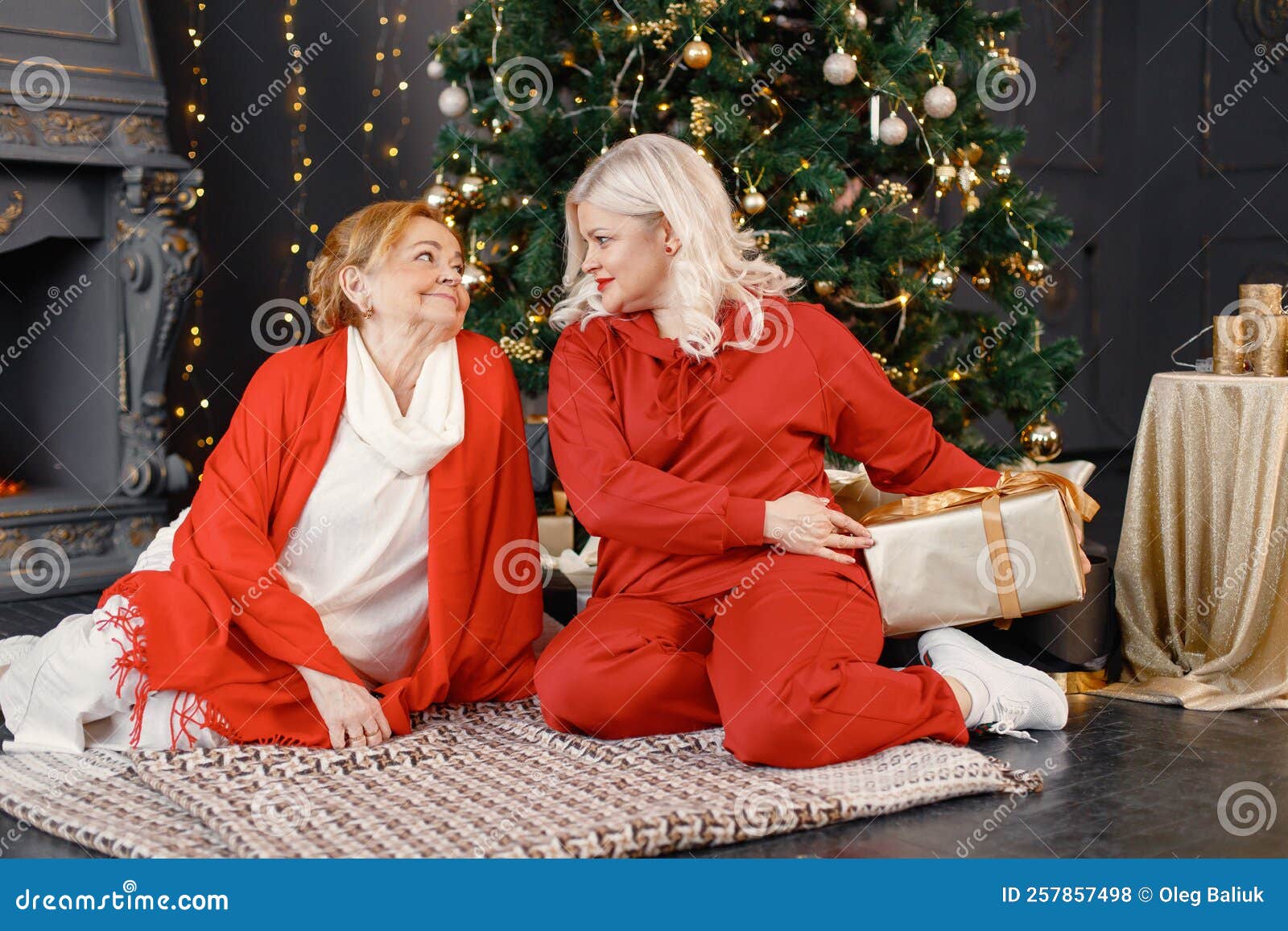 Old Woman With Her Adult Daughter Sitting Near Christmas Tree Stock