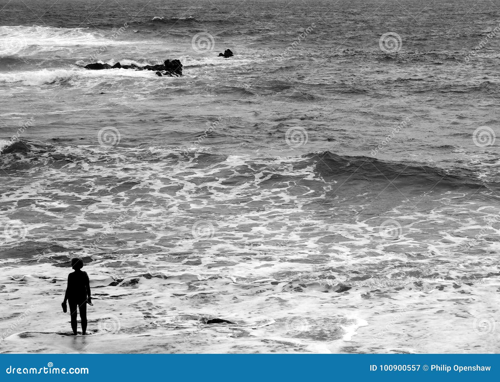An Old Woman Standing Alone in the Sea in the Evening with Waves ...